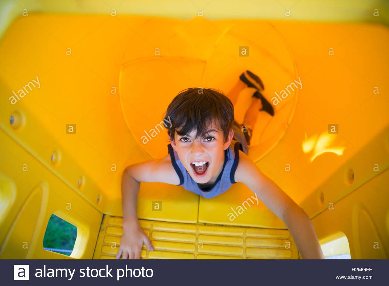 Boy playground slide yellow hi-res stock photography and images - Alamy