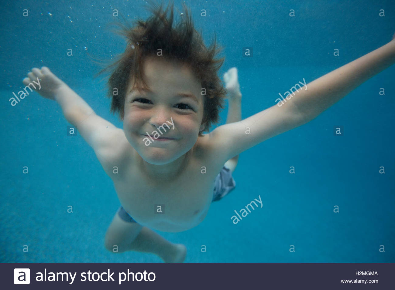 Portrait smiling boy holding breath underwater in swimming pool Stock ...