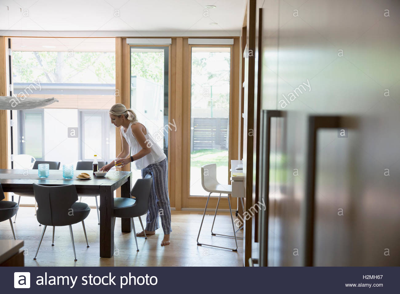 Woman placing breakfast on dining table Stock Photo - Alamy