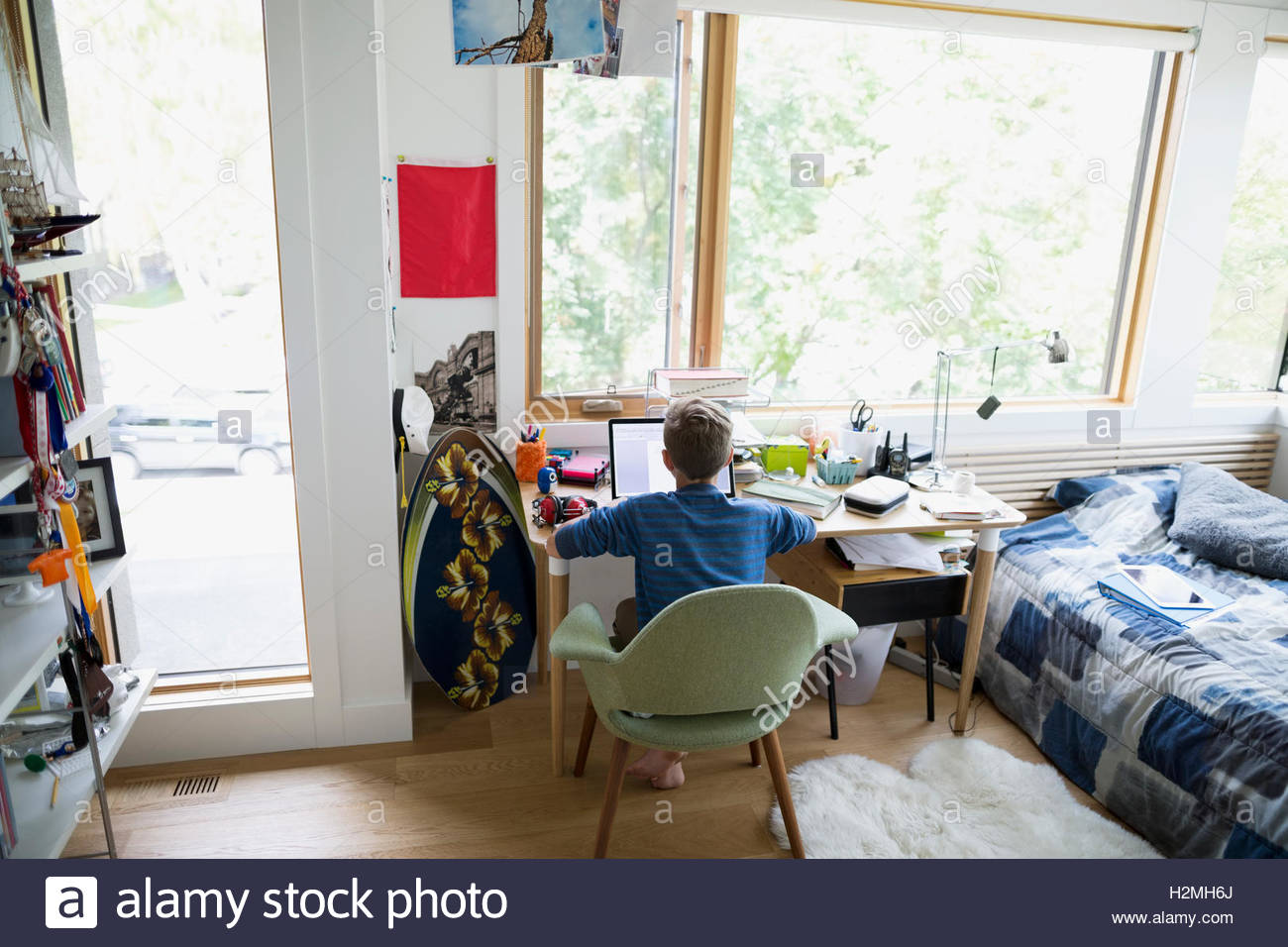 Boy using laptop in bedroom Stock Photo - Alamy