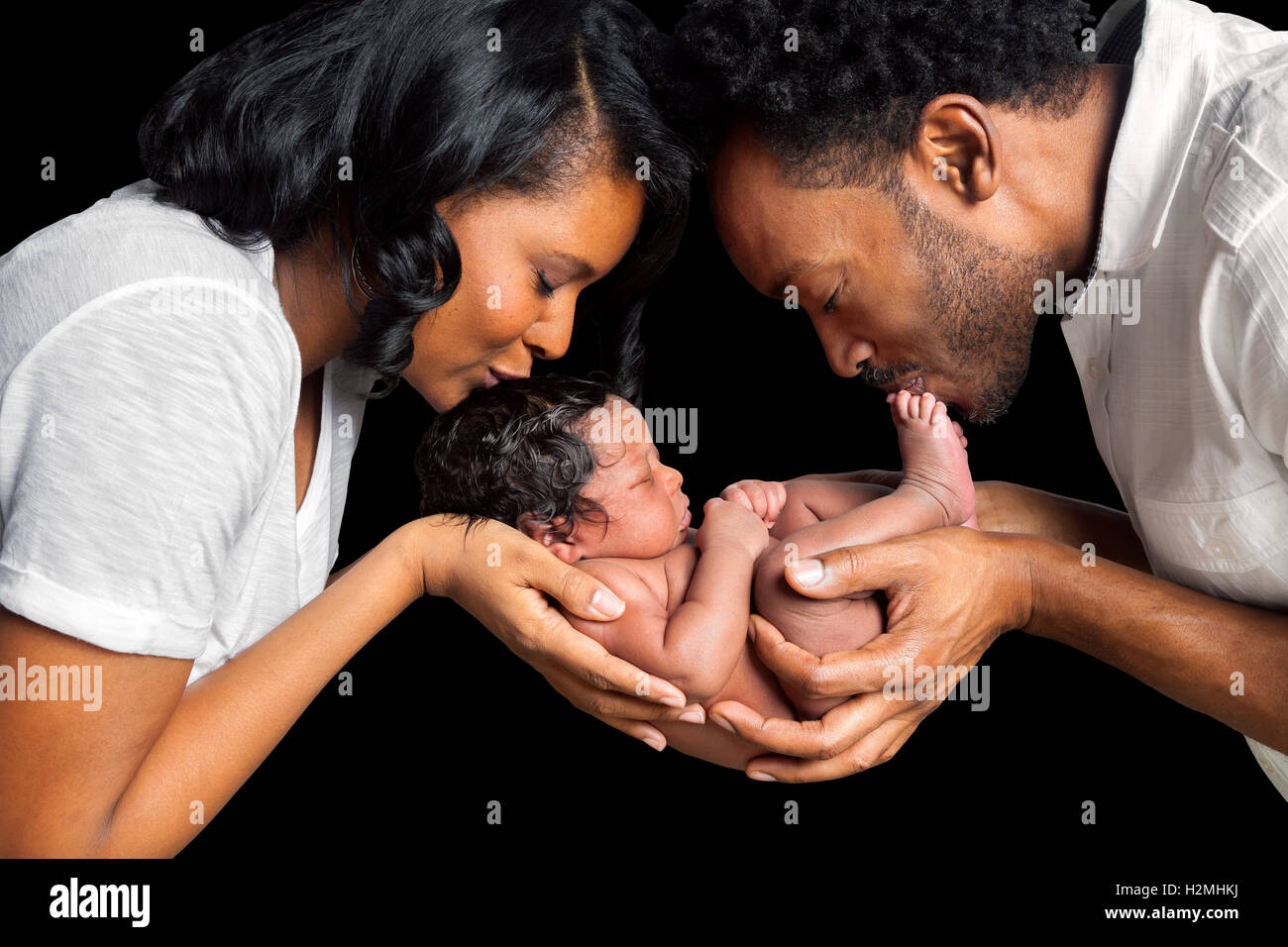 A good looking African American couple cradles their newborn daughter ...
