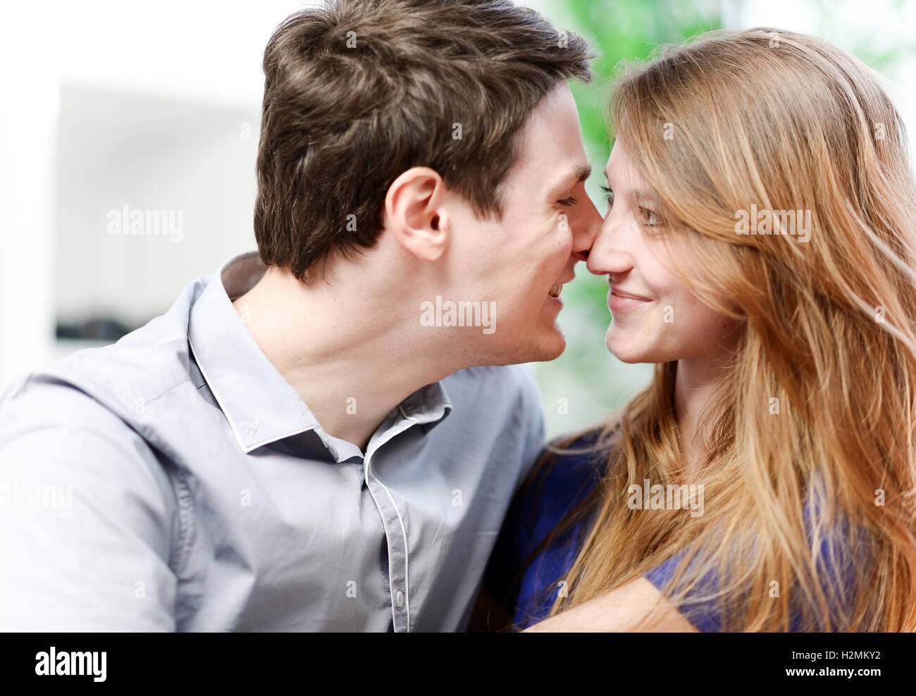 Very attractive young couple flirting on a sofa Stock Photo - Alamy