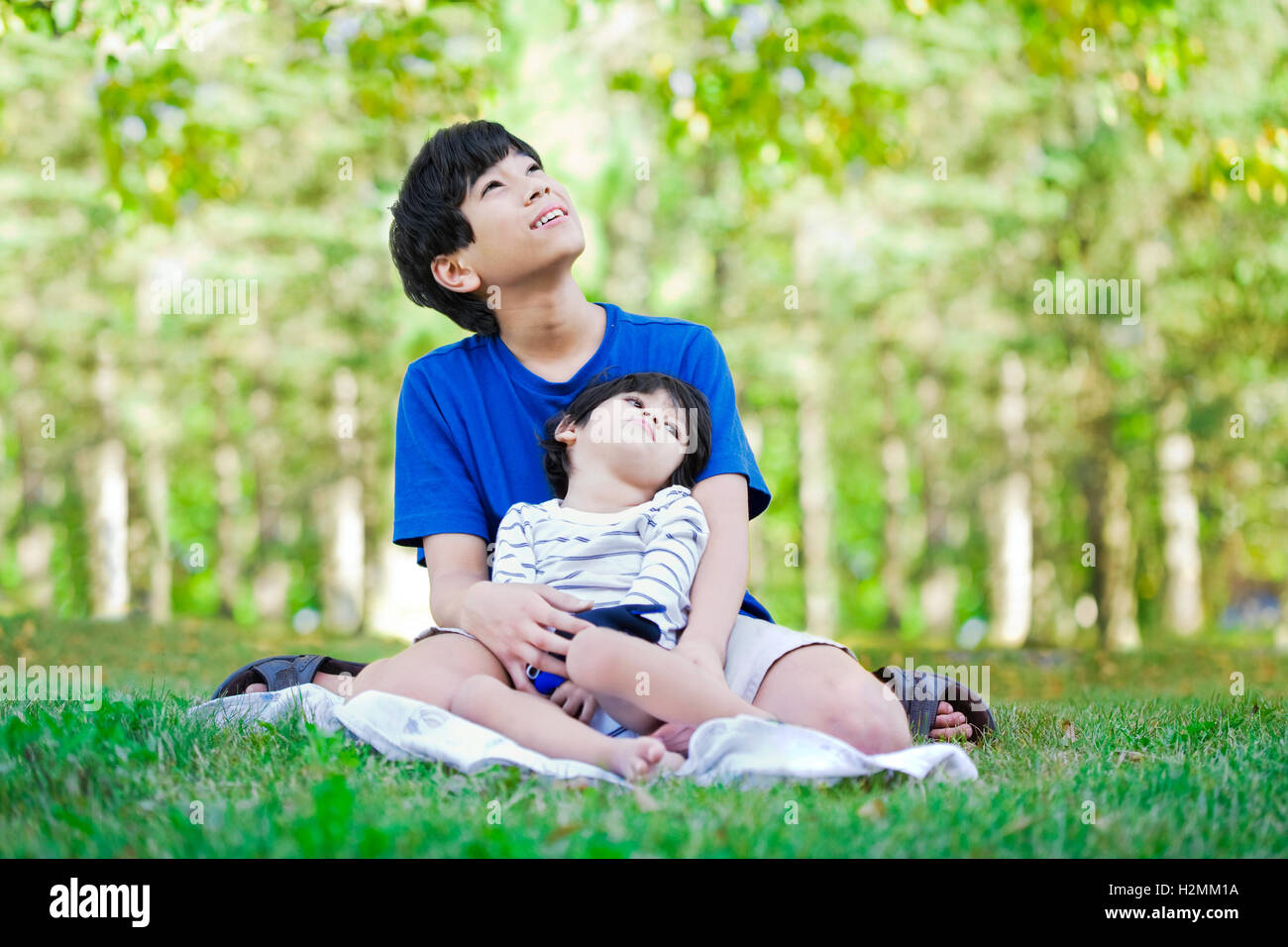 Young teen boy caring for disabled brother Stock Photo - Alamy