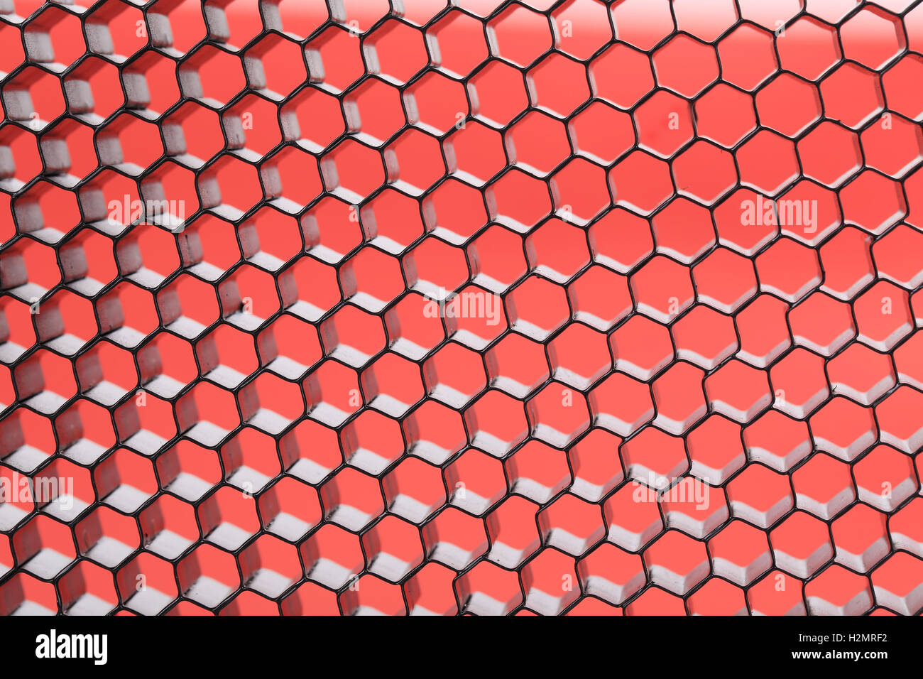 Hexagonal mesh on a red background Stock Photo - Alamy