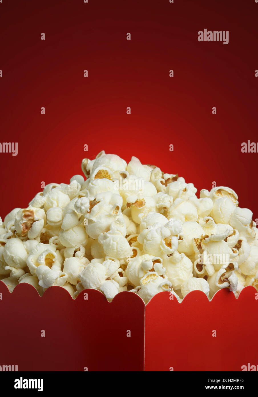 Box of popcorn and red background Stock Photo - Alamy