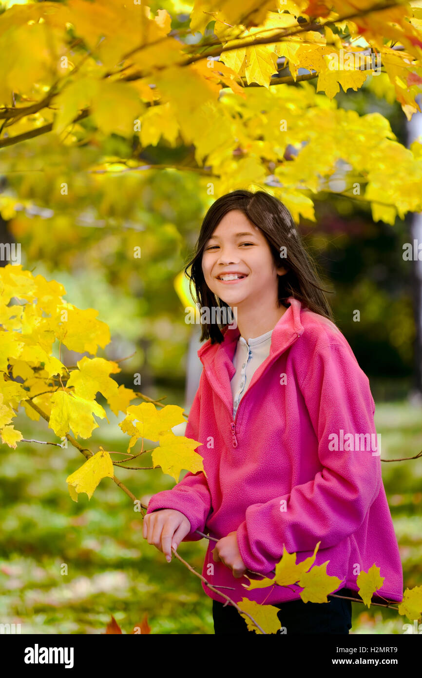 little biracial asian girl standing amongst bright autumn leaves Stock ...