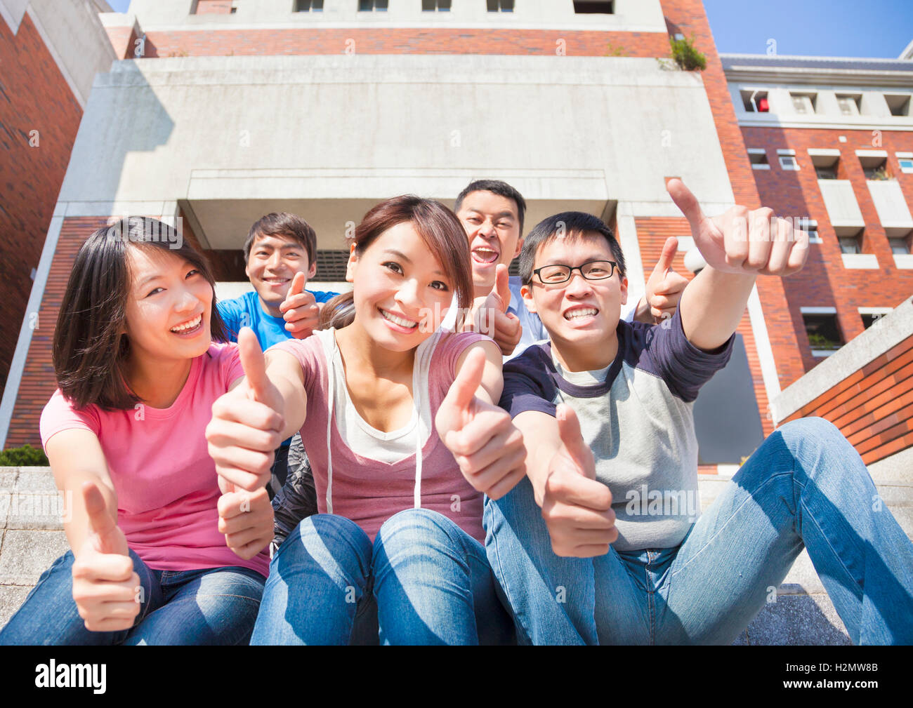 happy students thumbs up together Stock Photo - Alamy