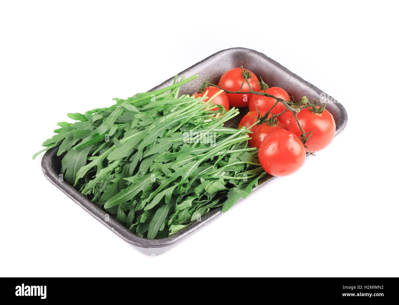 Tomatoes and arugula in plastic box Stock Photo - Alamy
