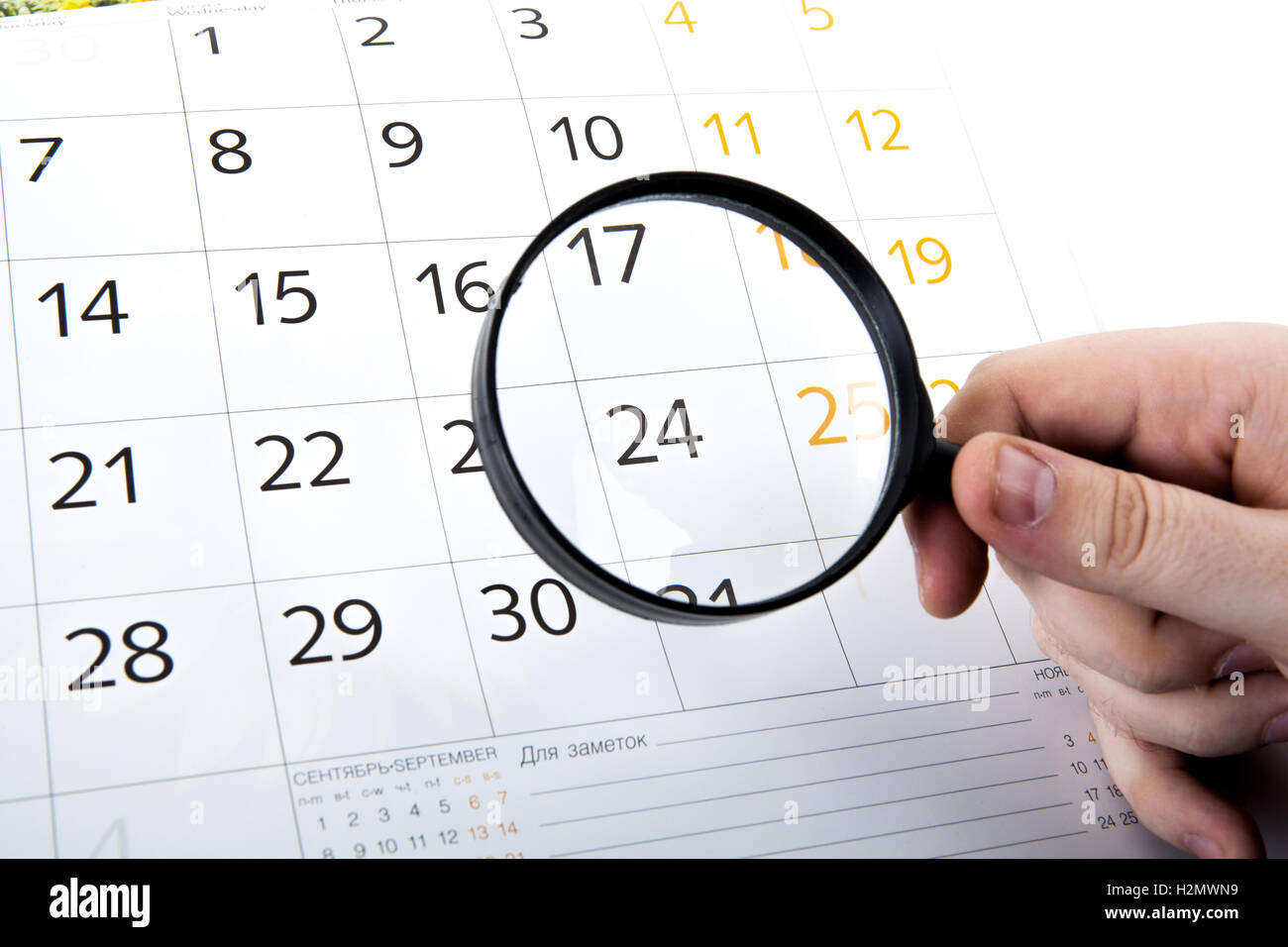 Magnifying glass in hand and the wall calendar Stock Photo - Alamy