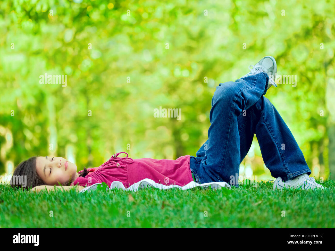 Little girl lying on grass lawn sleeping Stock Photo - Alamy