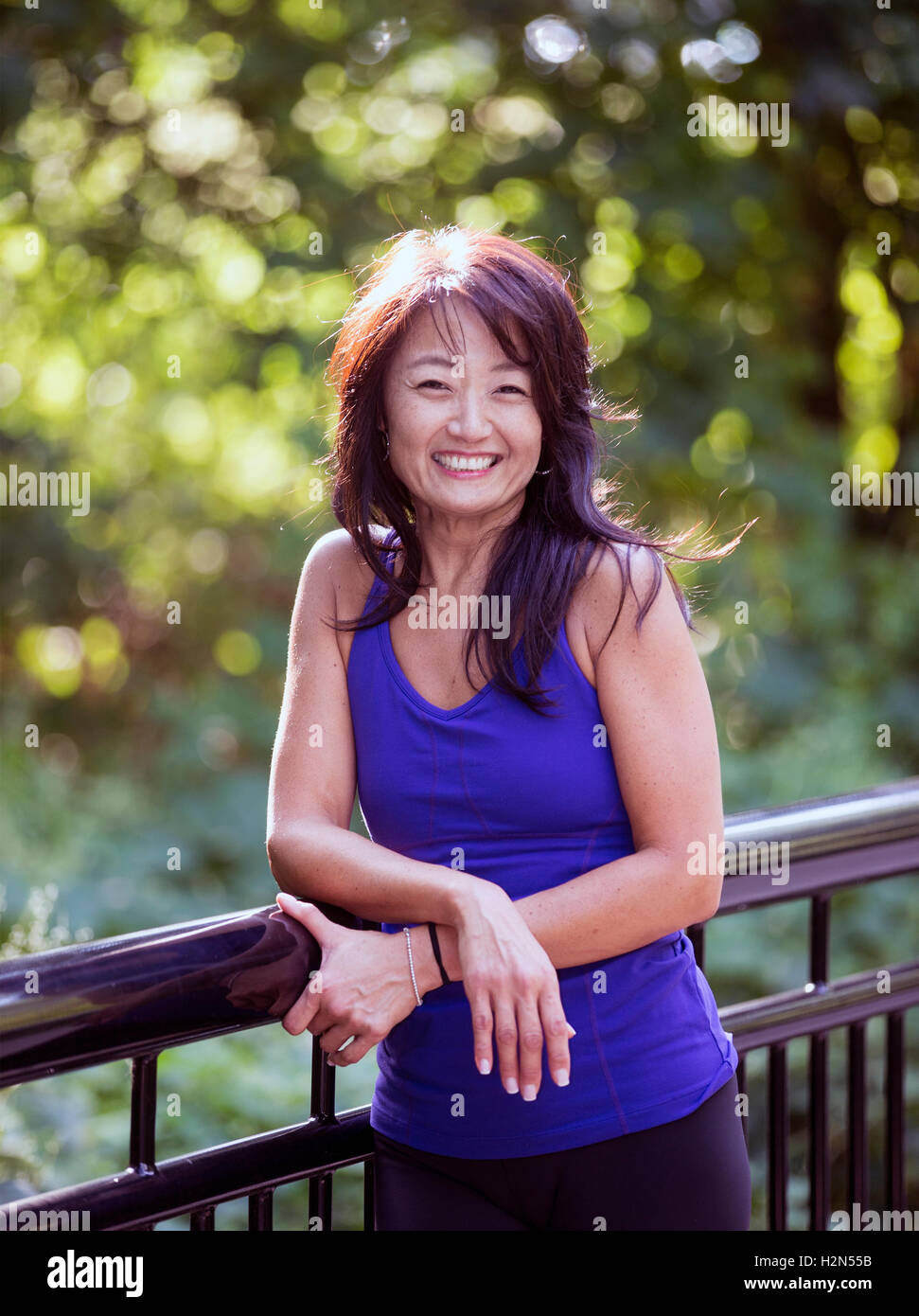 A fit Asian American woman taking a break from exercising Stock Photo ...