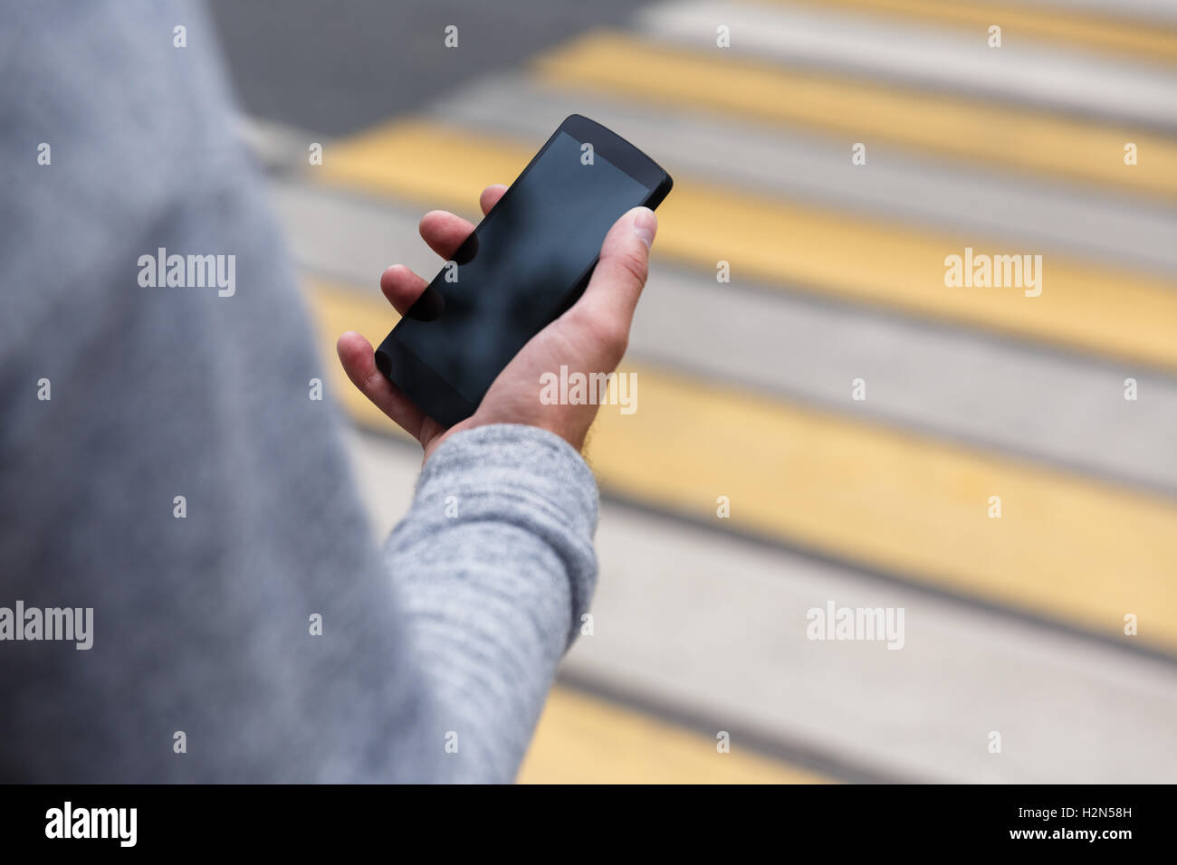 mobile phone in man's hand on street Stock Photo - Alamy
