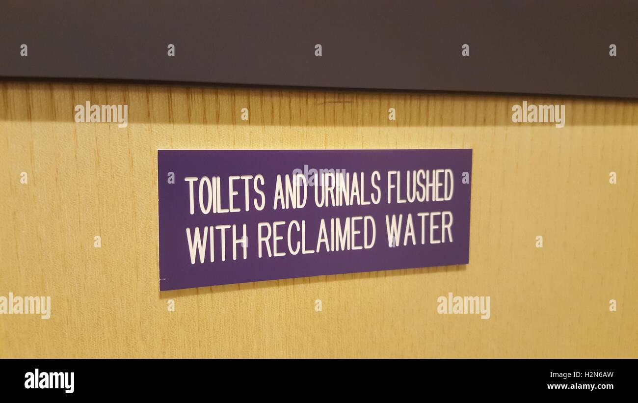 Purple colored sign on a public restroom indicating that the toilets in ...