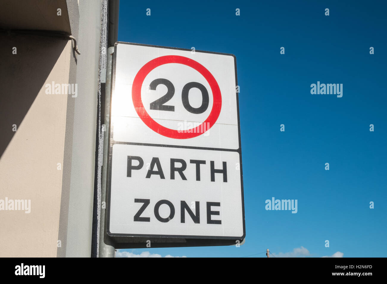Speed limit of 20mph zone and in Welsh. Sunny blue sky day in centre ...