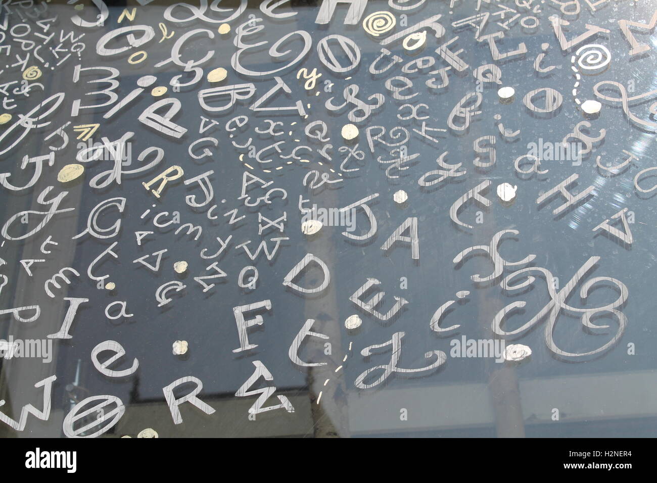 Letters of the alphabet and symbols painted on a window Stock Photo - Alamy