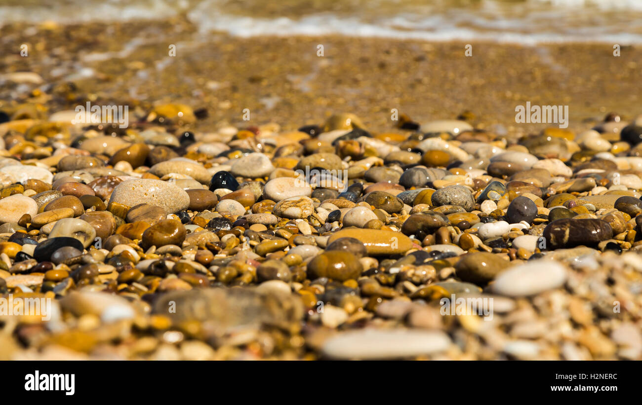 stone and sand at the shore in a sunny day Stock Photo - Alamy