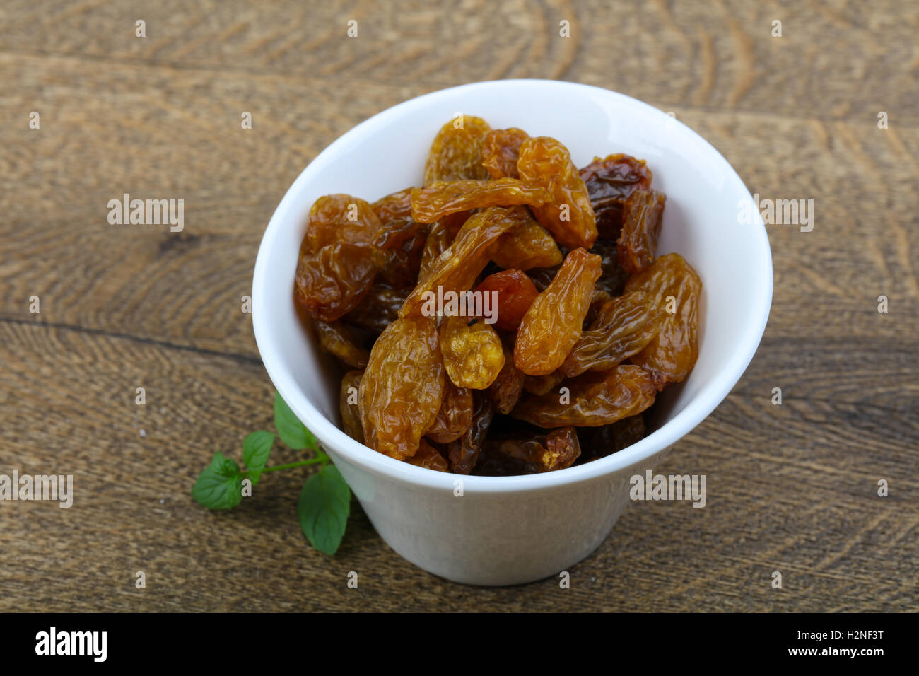 Sweet raisins in the bowl with mint leaves Stock Photo - Alamy