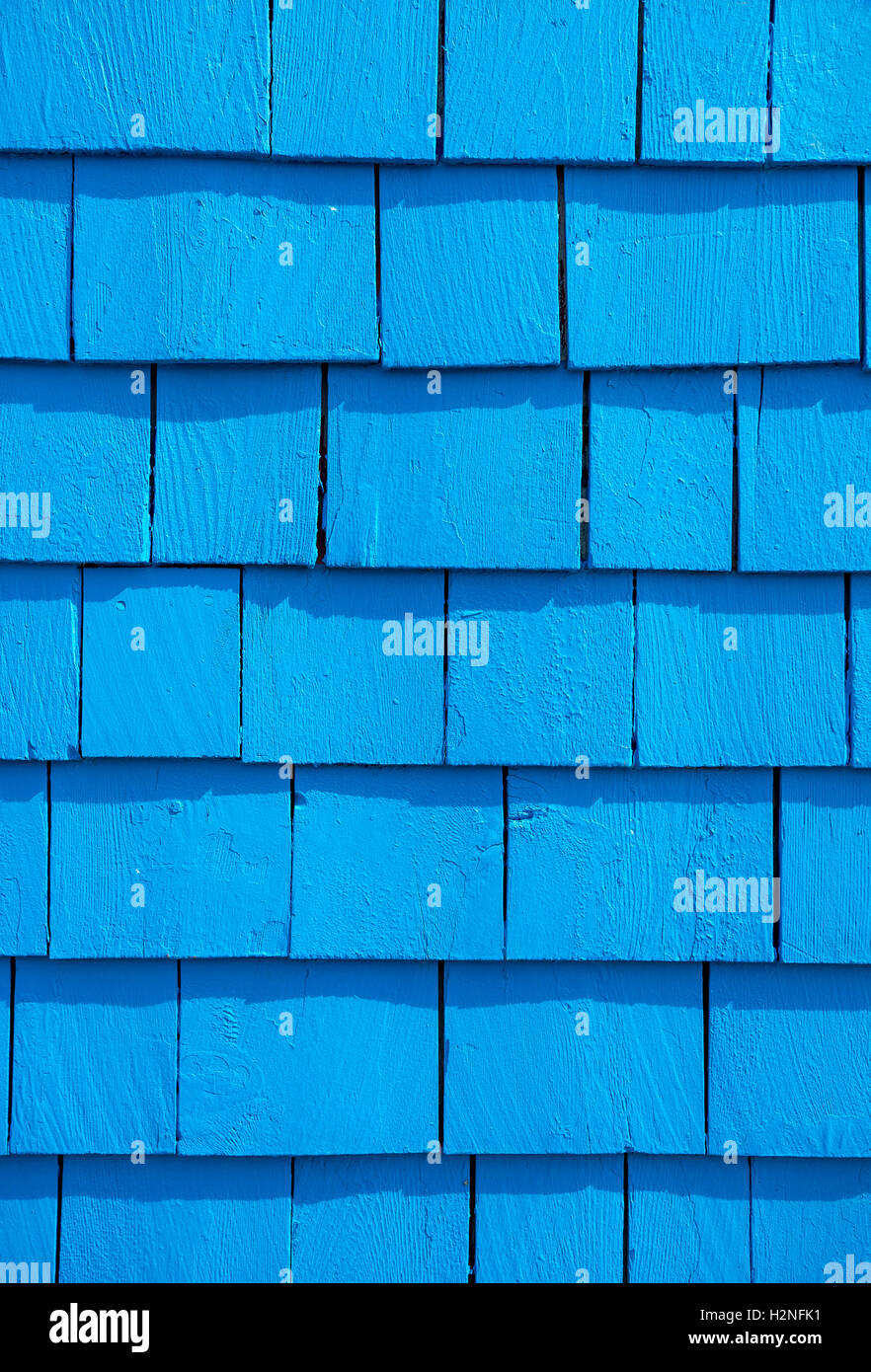 Abstract background of blue shingles on the side of a brightly painted ...