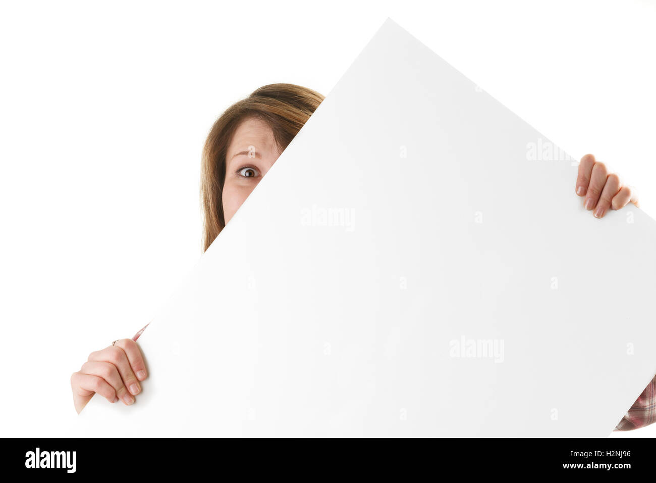 Woman peeking from behind a white sign Stock Photo - Alamy