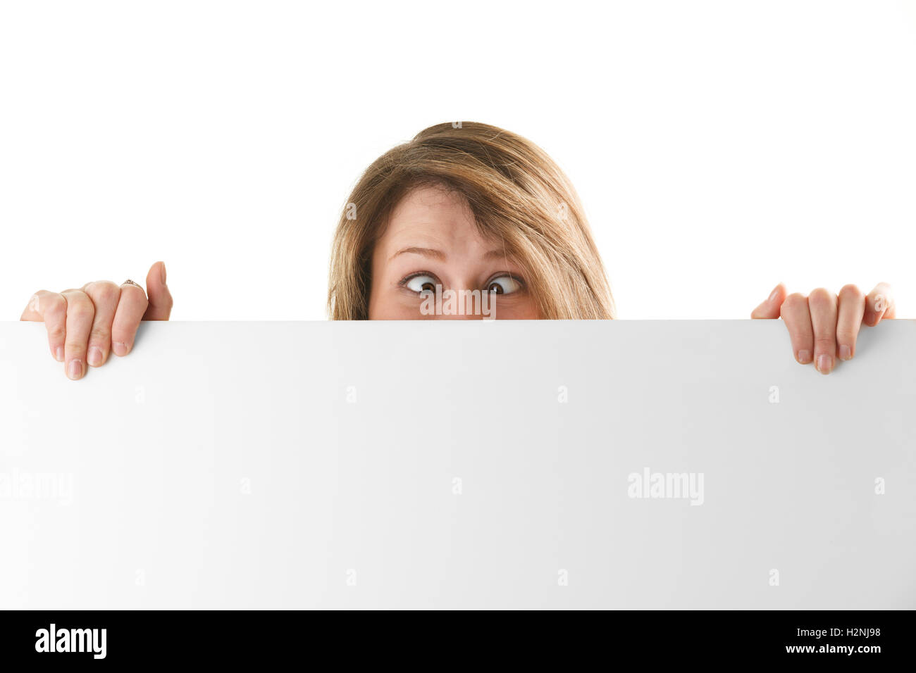 Woman peeking from behind a white sign Stock Photo - Alamy
