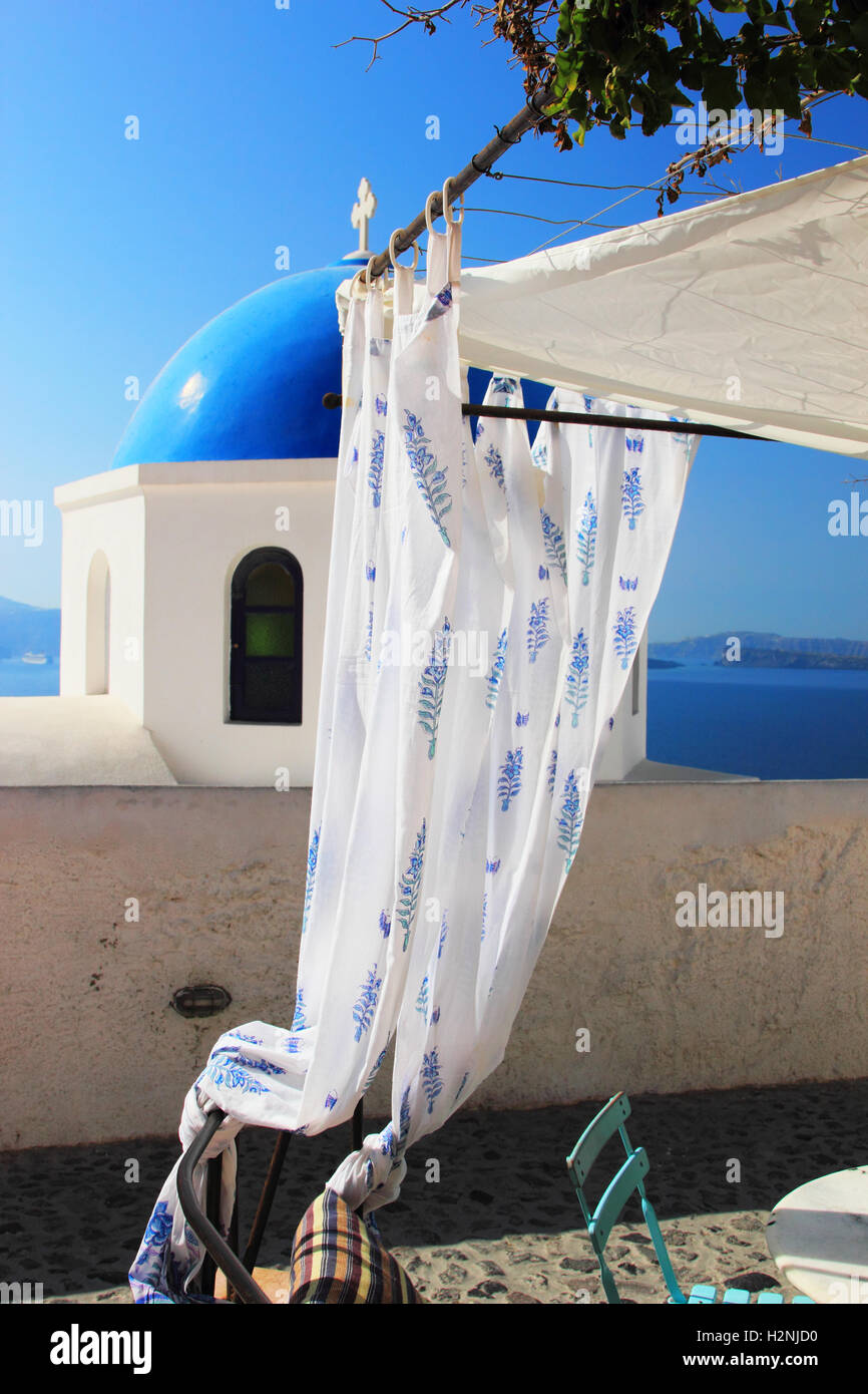 Traditional Greek white church arch with cross and bells in village Oia ...