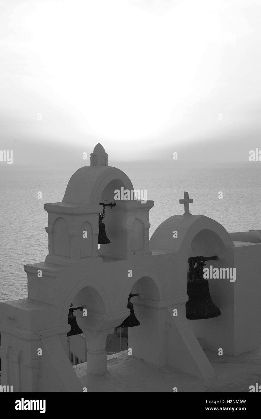 Traditional Greek white church arch with cross and bells in village Oia ...