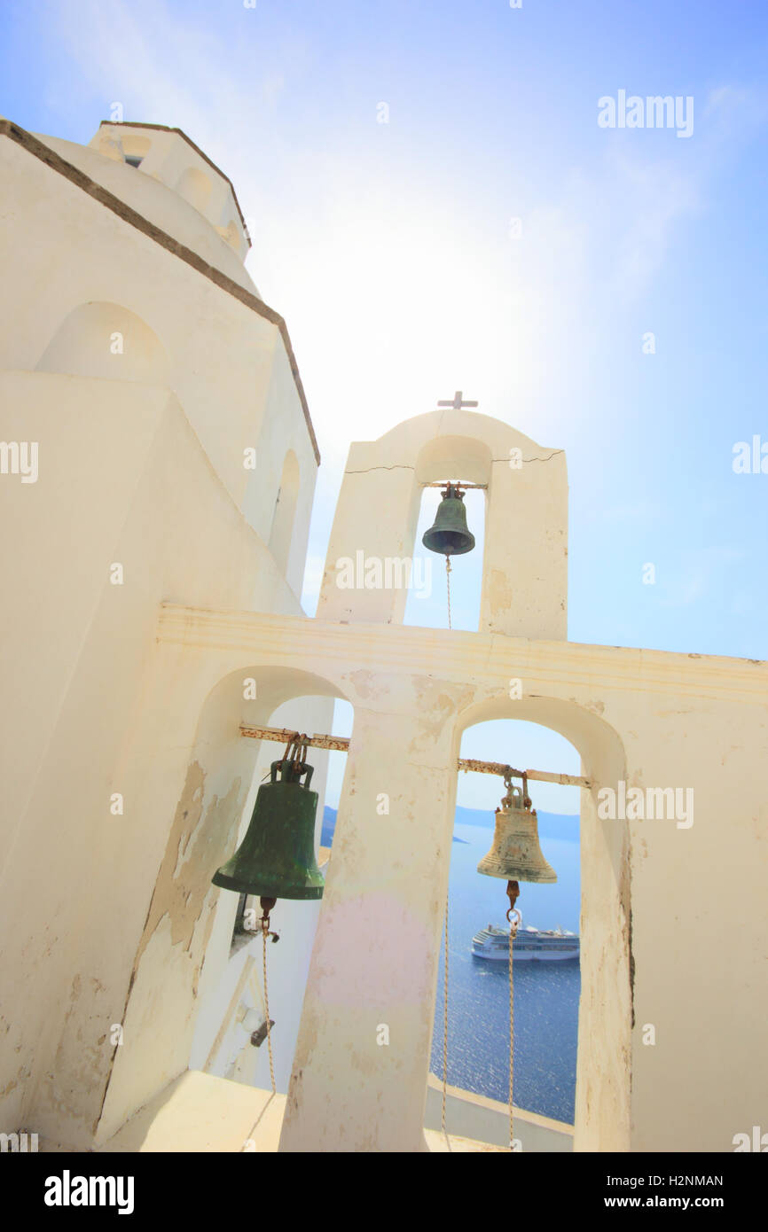 Traditional Greek white church arch with cross and bells in village Oia ...