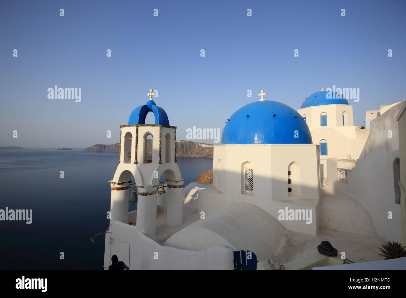 Traditional Greek white church arch with cross and bells in village Oia ...