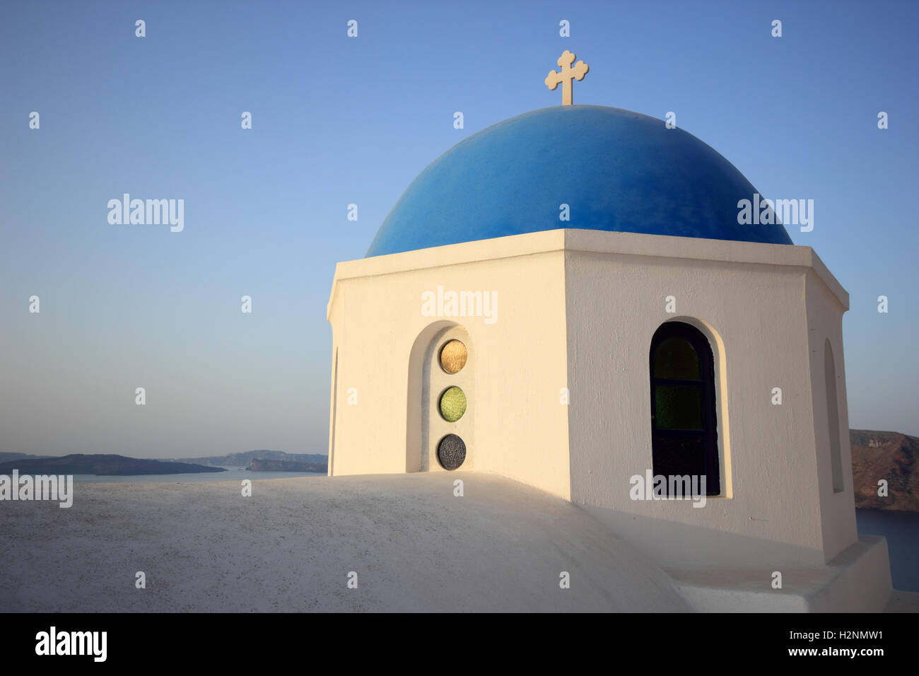 Traditional Greek white church arch with cross and bells in village Oia ...