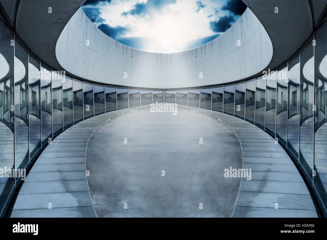 Empty oval arena with surrounding glass panels. The ceiling is open and ...