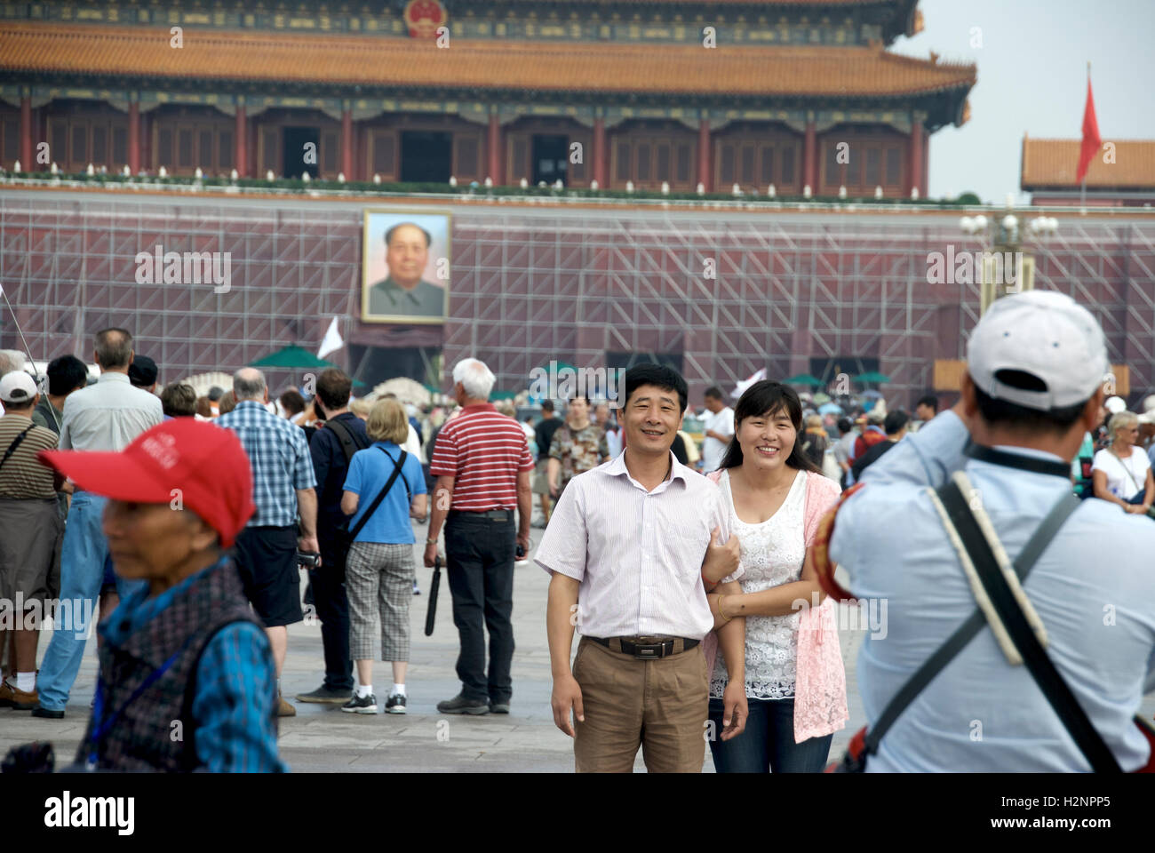 A proud Chinese couple poses in front of Chairman Mao's portrait at ...
