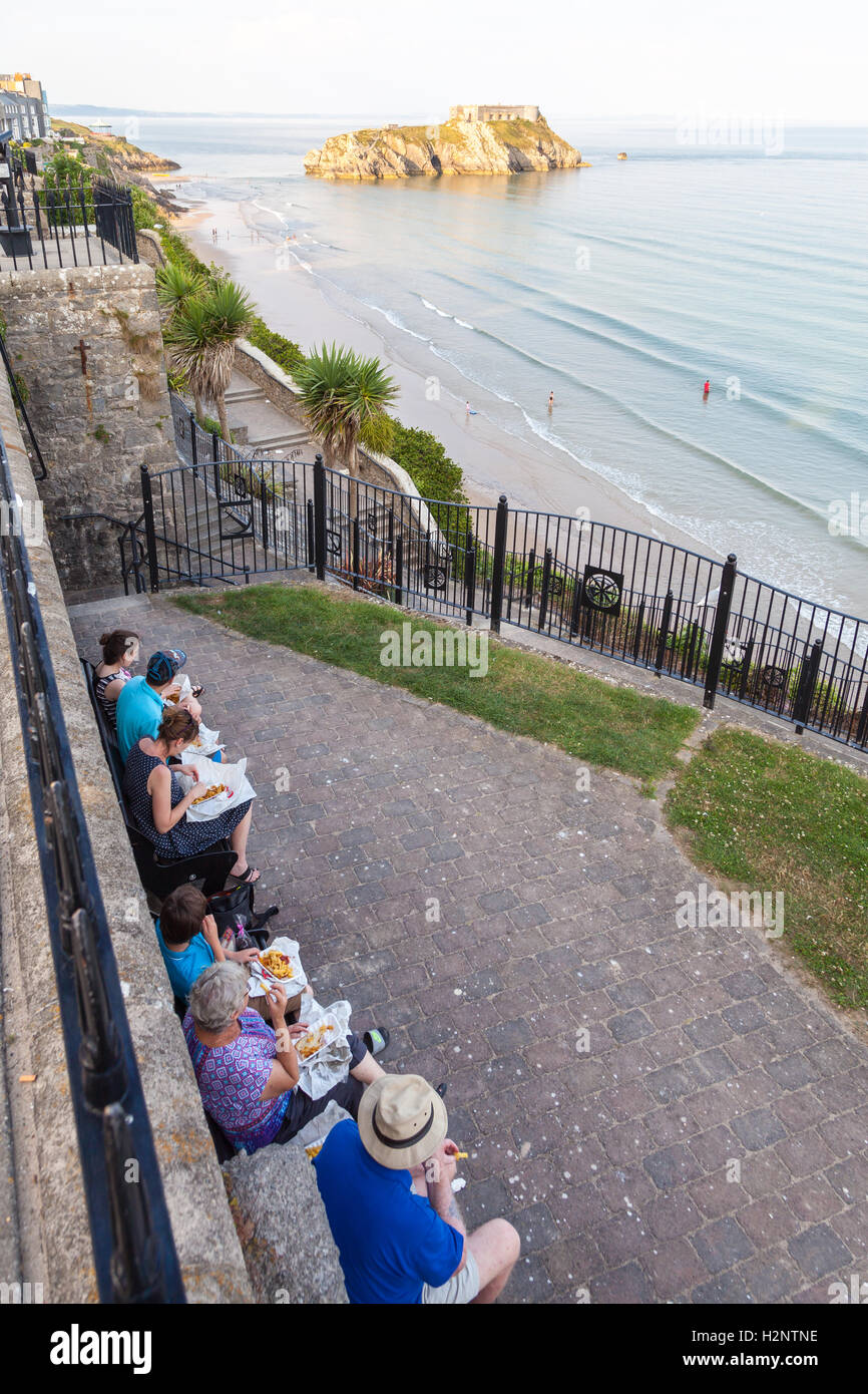 People eating chips at Tenby front Stock Photo - Alamy