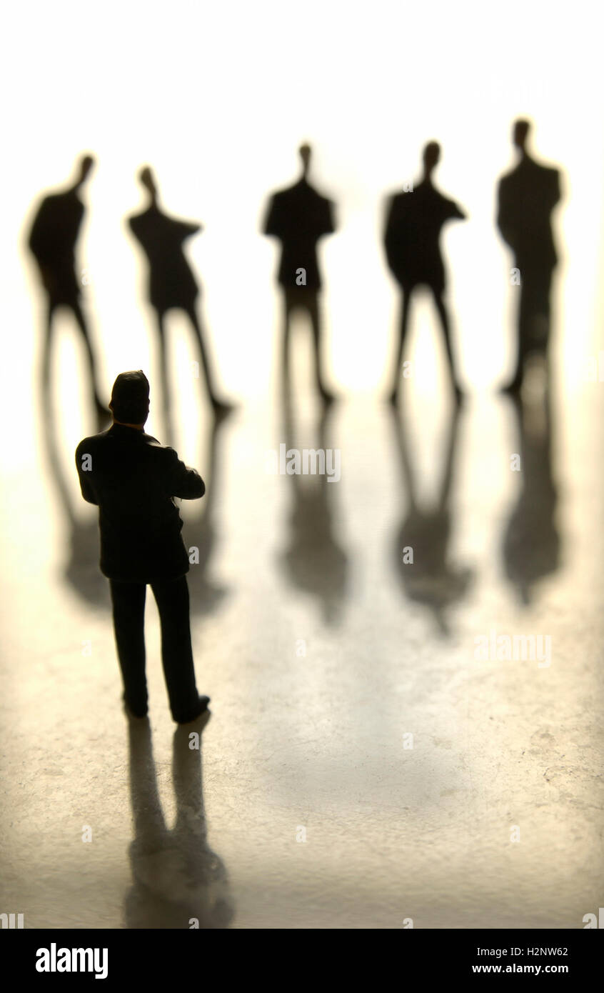 Row of figurines, one watching the others Stock Photo - Alamy