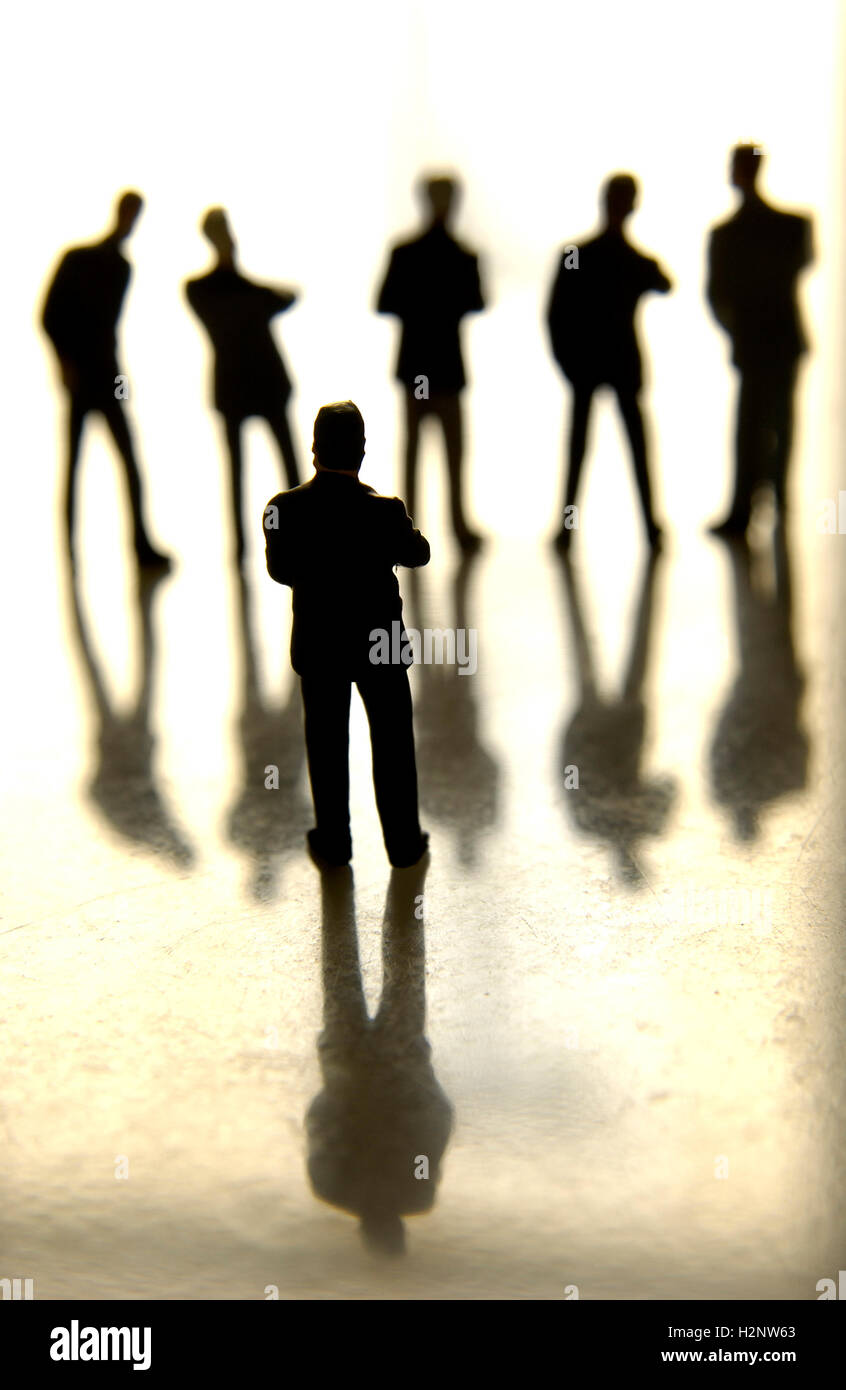 Row of figurines, one watching the others Stock Photo - Alamy