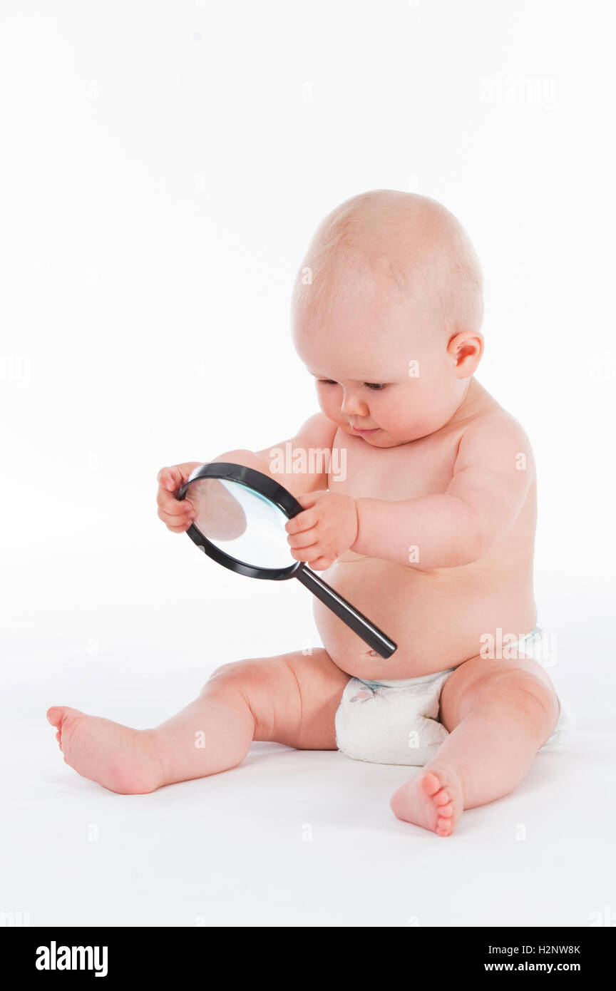 Baby, ten months, with magnifying glass Stock Photo - Alamy
