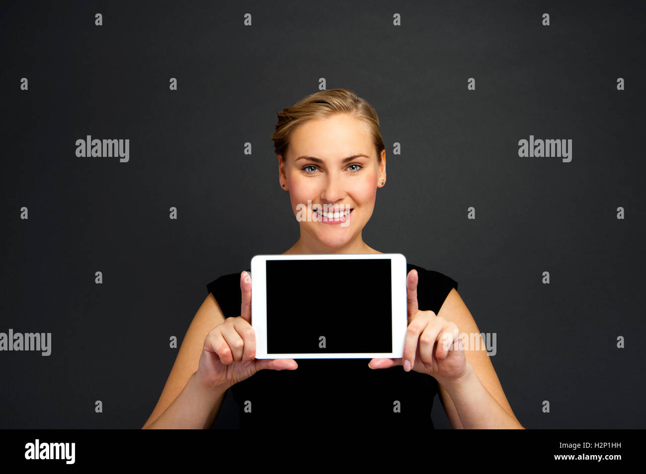 Business woman holding a tablet computer - isolated over a dark ...