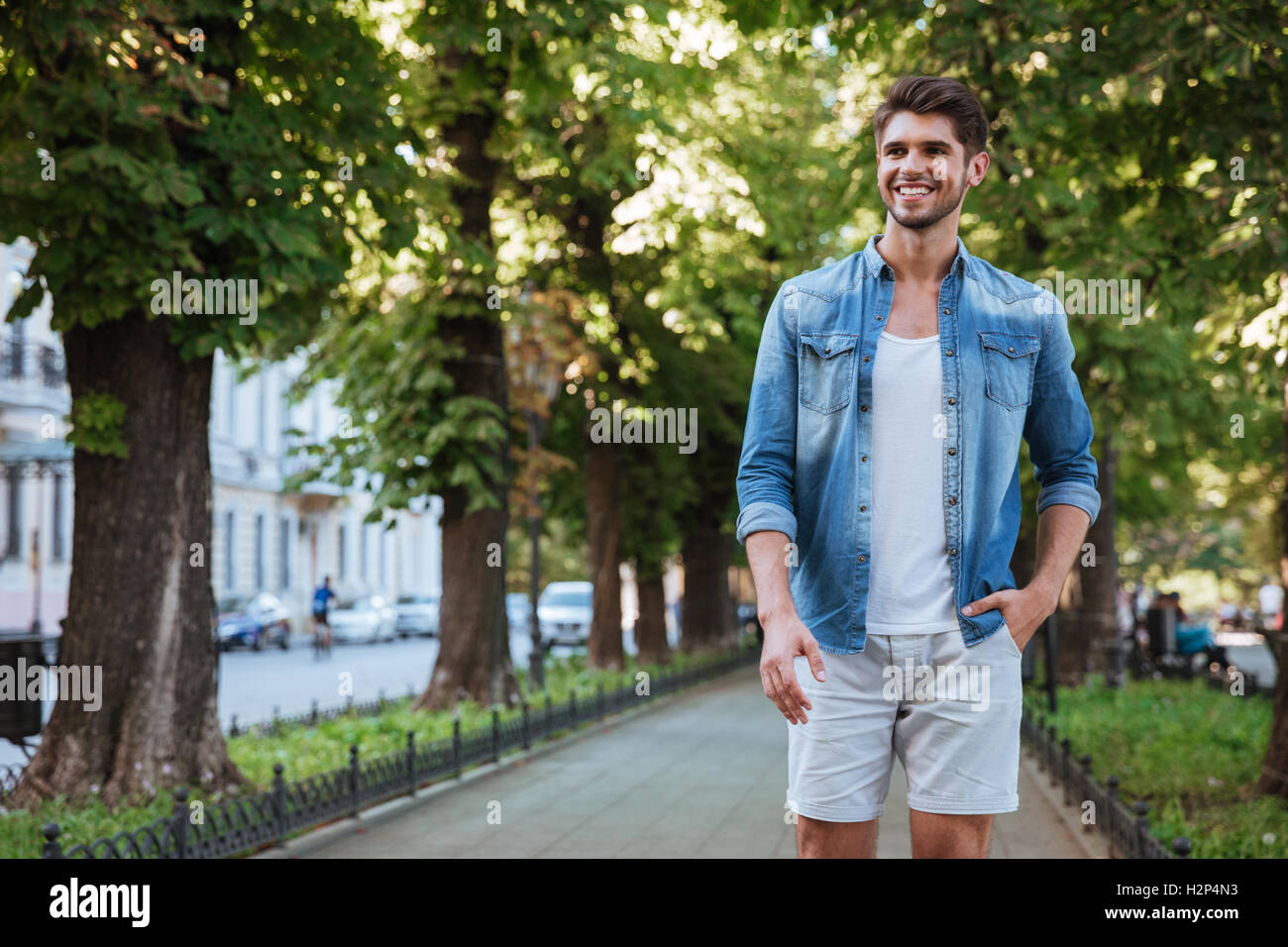 Cheerful young man walking in the city Stock Photo - Alamy