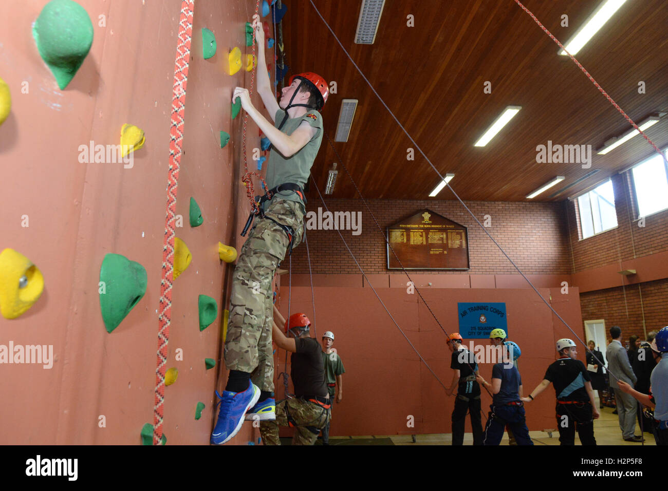 A climber makes process up a climbing wall to achieve his goal of ...