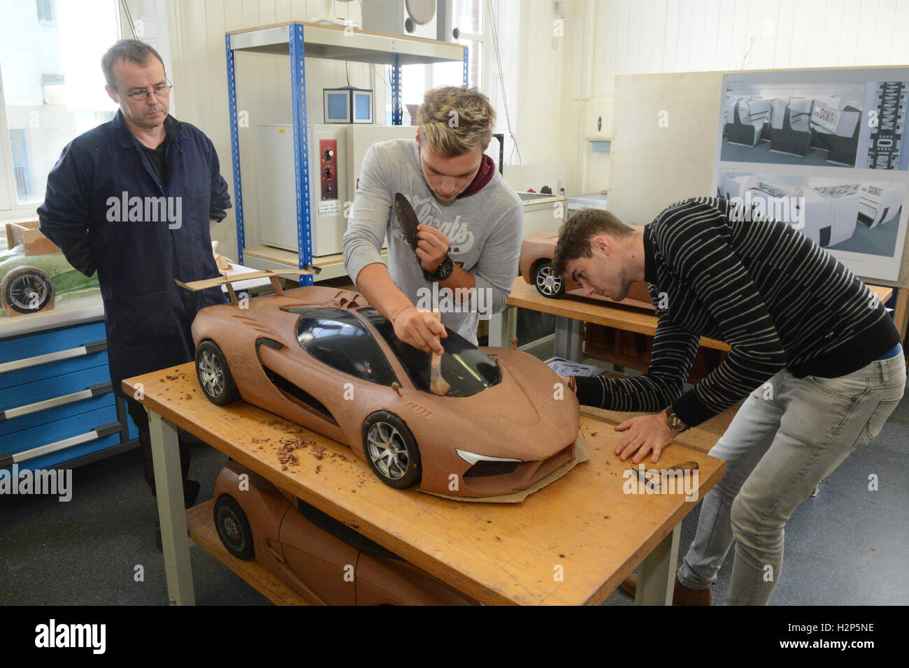 A model car is worked on with manual tools in the design process by ...