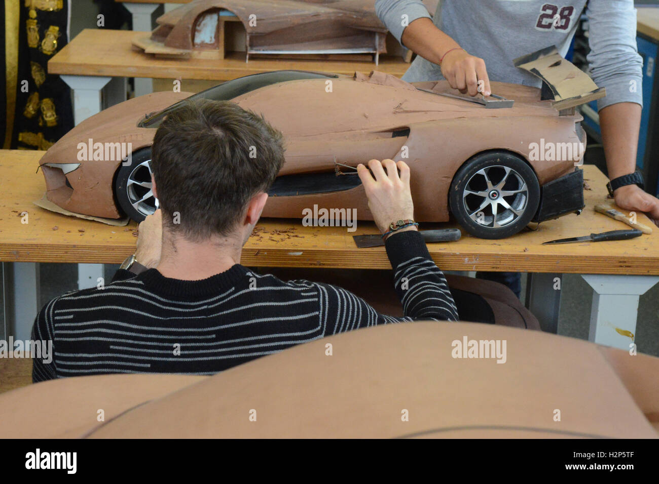 A model car is worked on with manual tools in the design process by ...