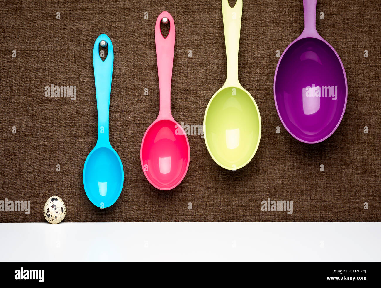 Scale of spotted egg and hanging multicolor measuring spoons Stock ...