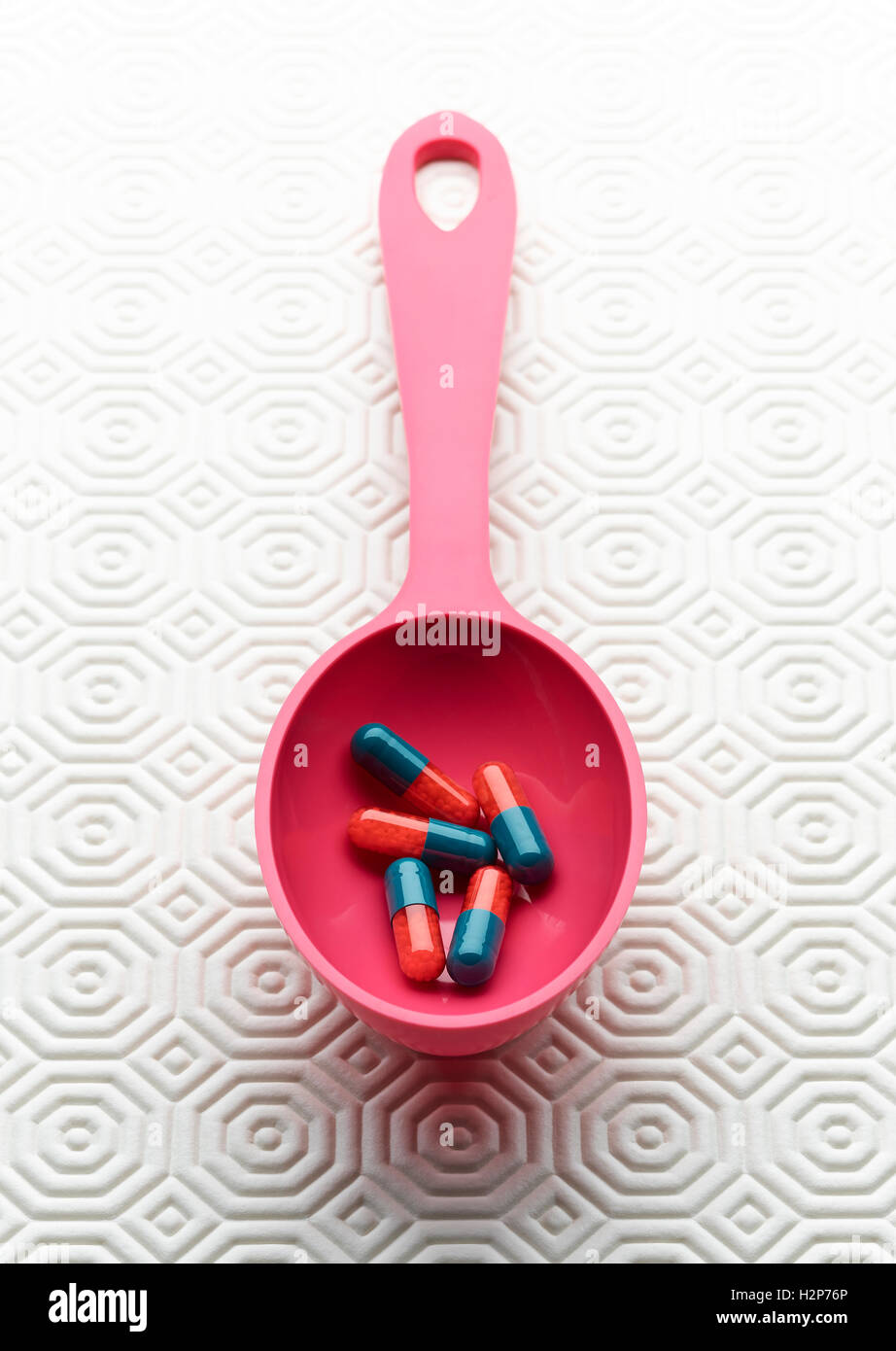 Medical capsules in pink spoon Stock Photo - Alamy