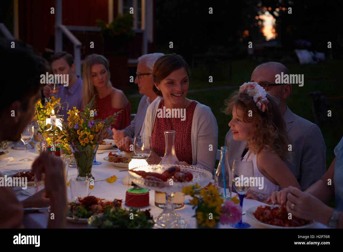 Family enjoying candlelight patio dinner at night Stock Photo - Alamy