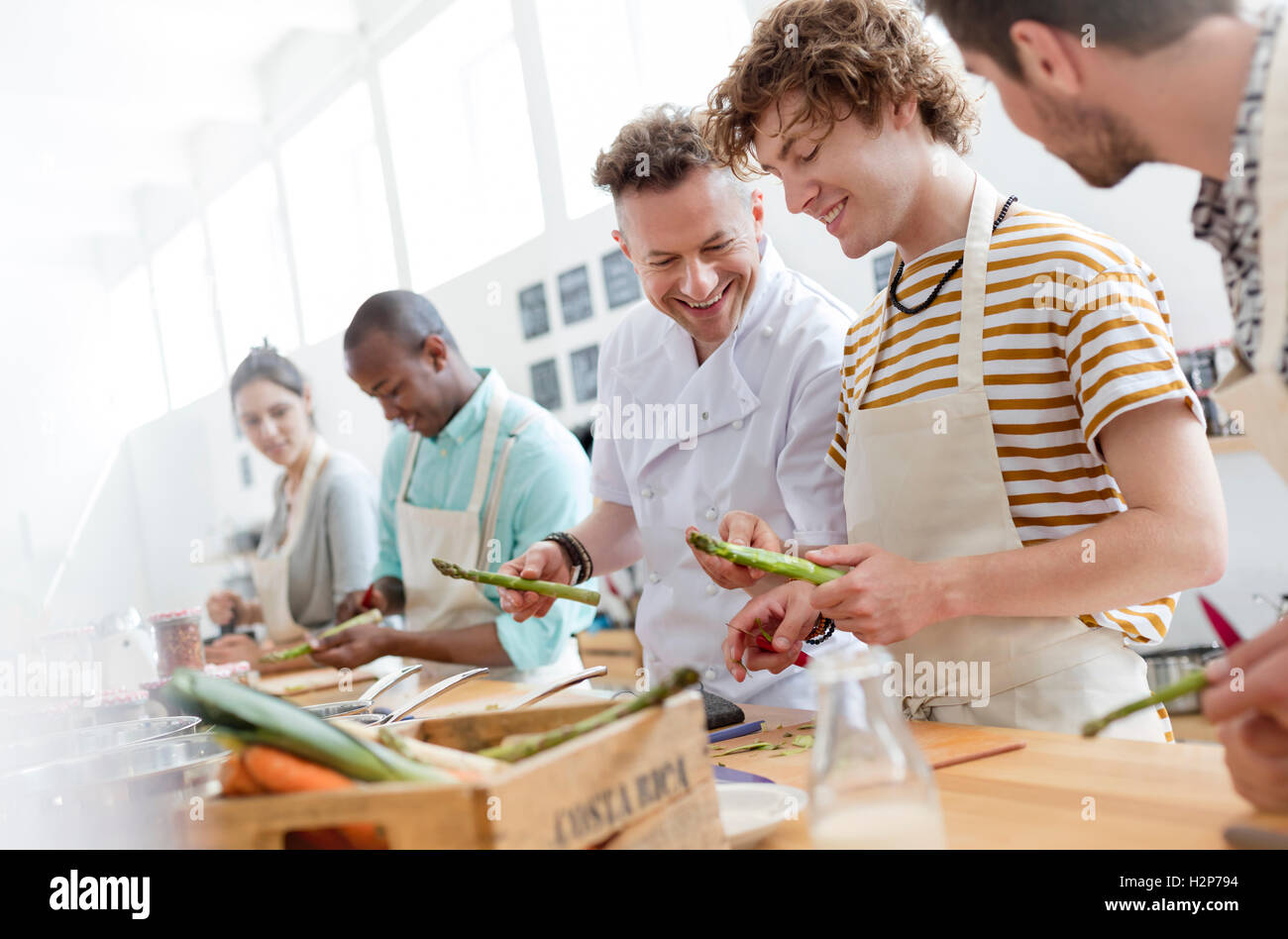 Chef teacher and students in cooking class kitchen Stock Photo - Alamy
