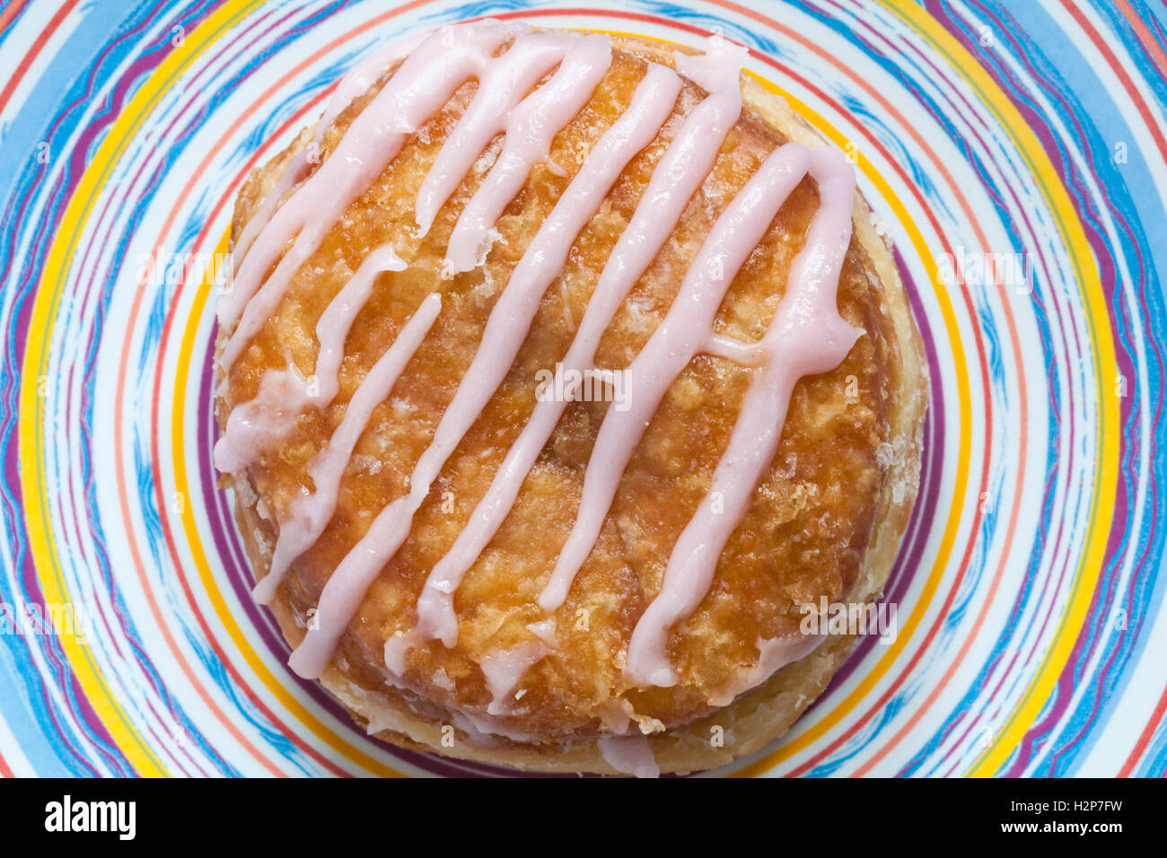 M&S Raspberry Yum Yums iced doughnut on colourful plate Stock Photo - Alamy