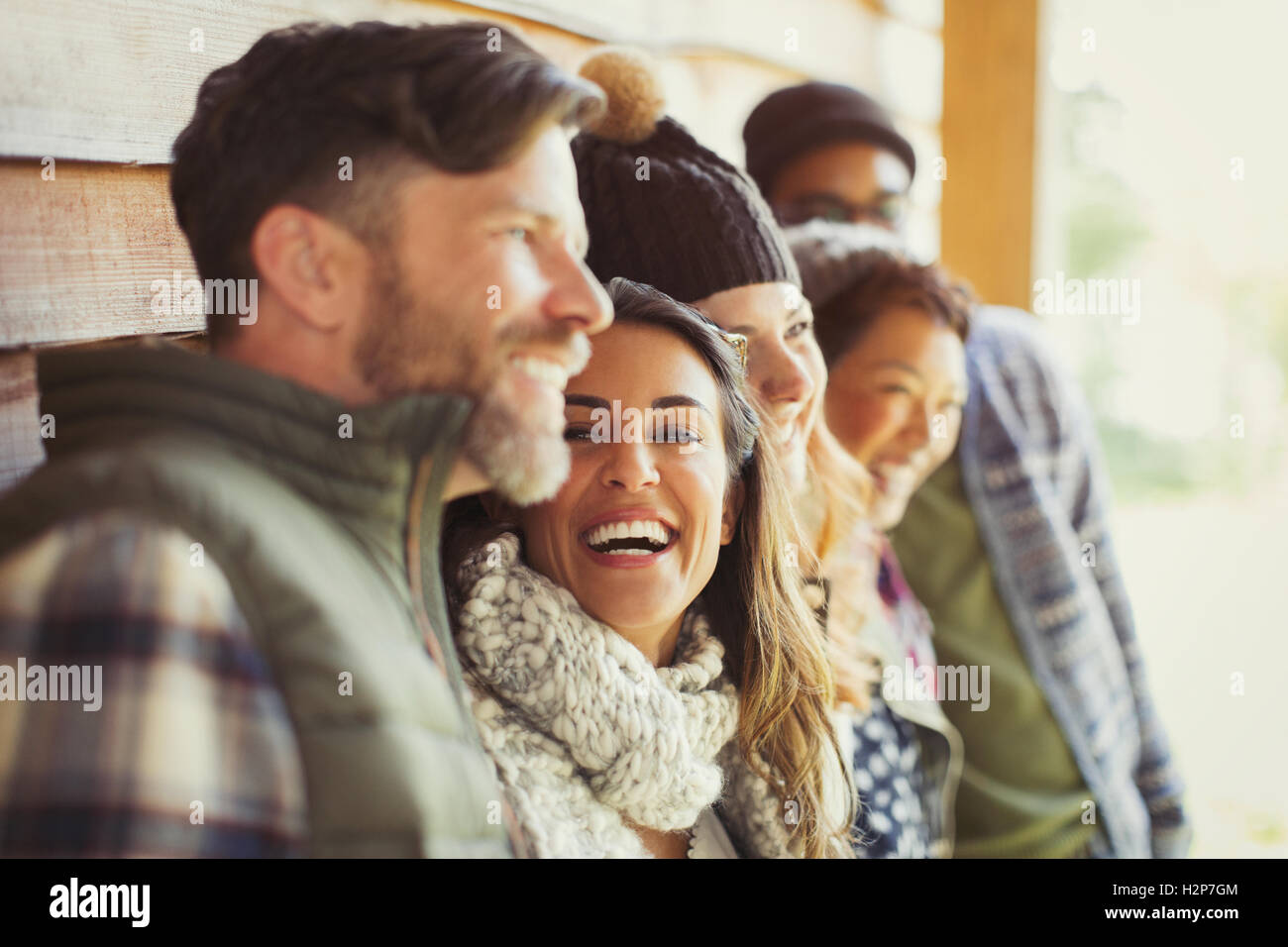 Friends laughing outside cabin Stock Photo - Alamy
