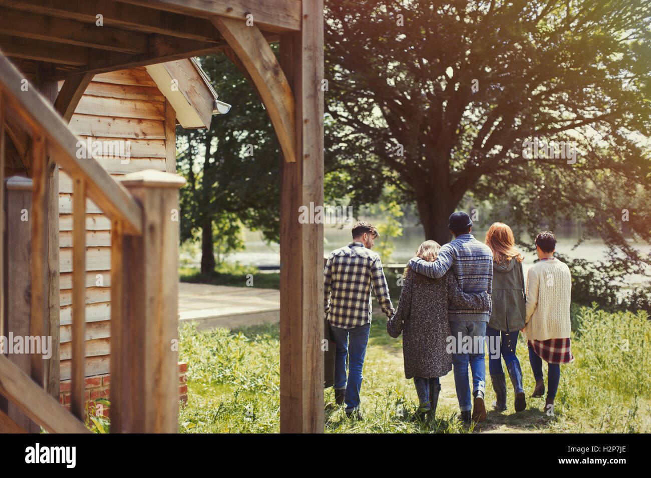 Friends walking outside lakeside cabin Stock Photo - Alamy