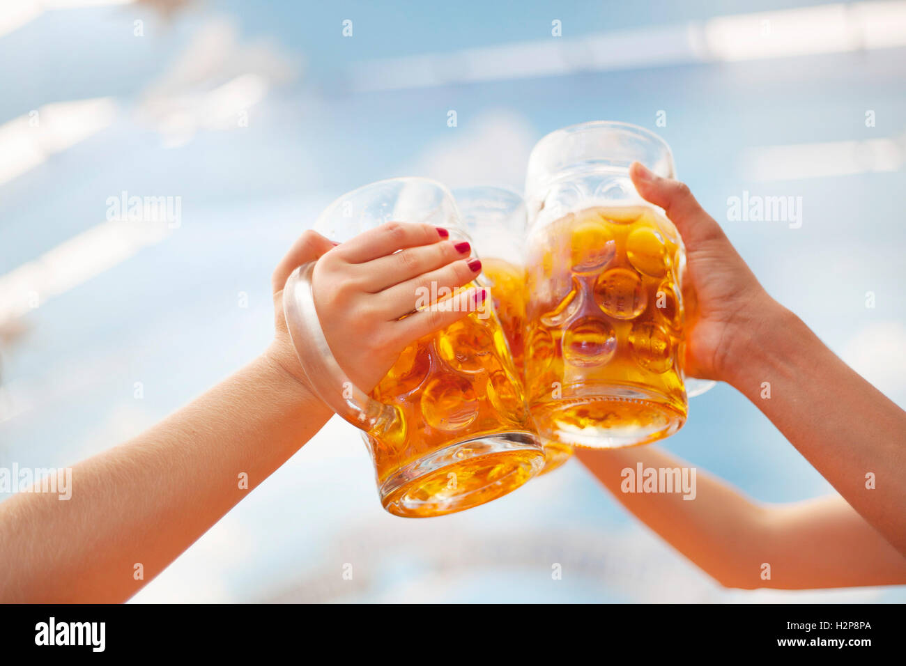 Raised beer mug toasting at Oktoberfest Stock Photo - Alamy