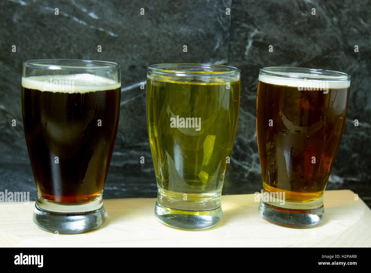 Flight of pale ale, red ale and dark beer on wooden tray Stock Photo ...
