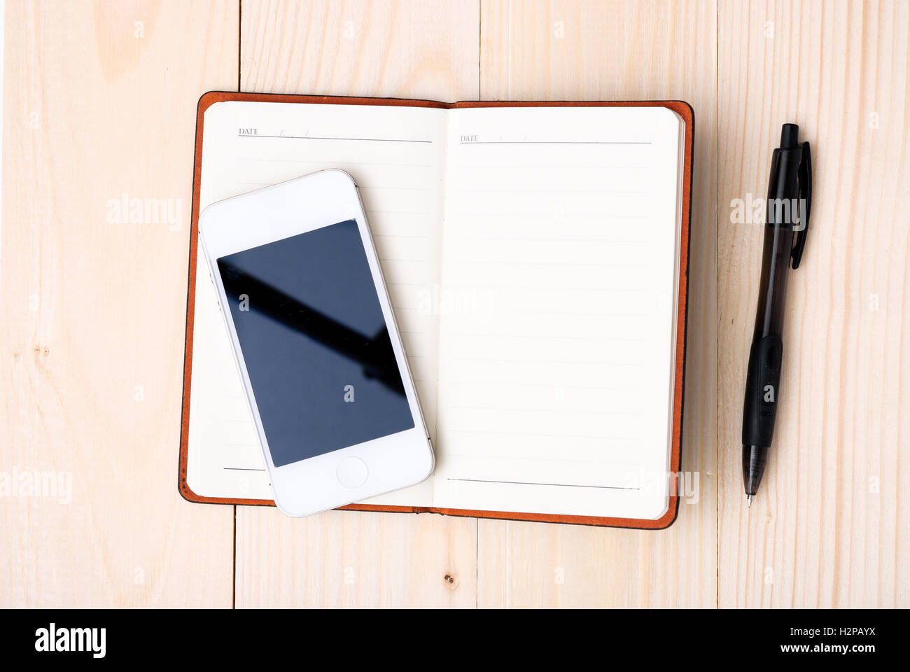Small notepad with pen and smartphone Stock Photo - Alamy